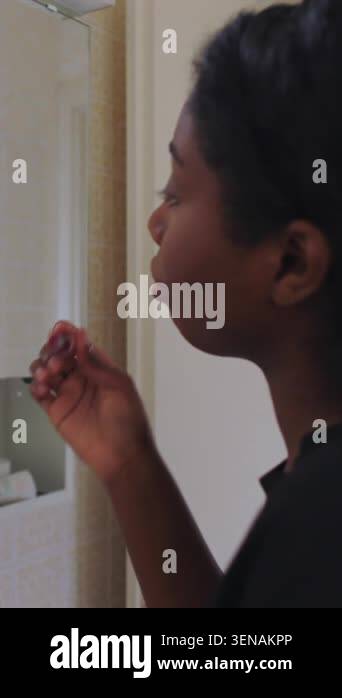 Young African American Woman moisturizing lips with balm in modern ...