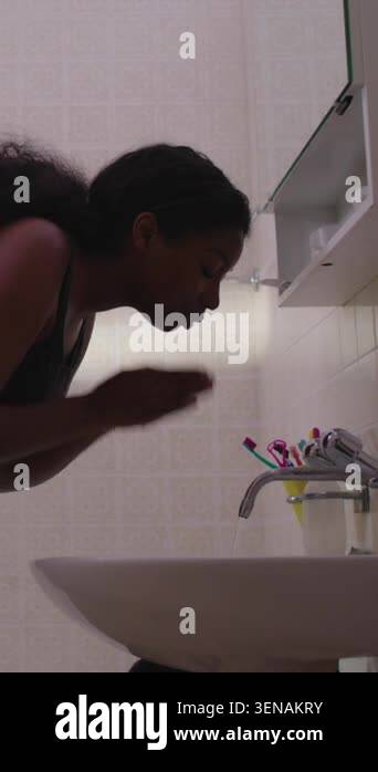 Young African American Woman practicing daily facial cleansing ritual ...