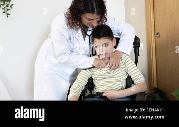 Caring female pediatrician using a stethoscope to examine a young ...