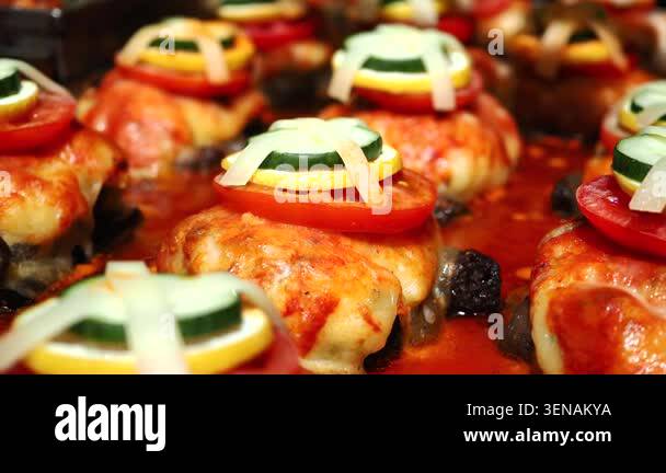 A chef prepares a meal using fresh vegetables and sauces in a kitchen ...