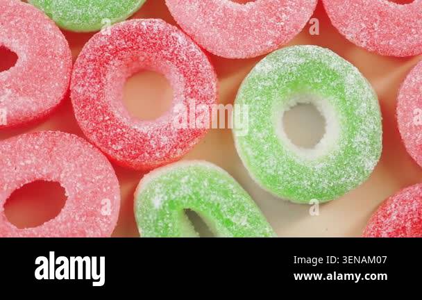Colorful gummy candy rings are laid out on a light surface Stock Video ...