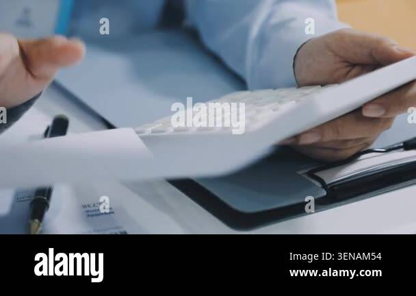 male hand holding digital tablet with calculator on desk in office ...