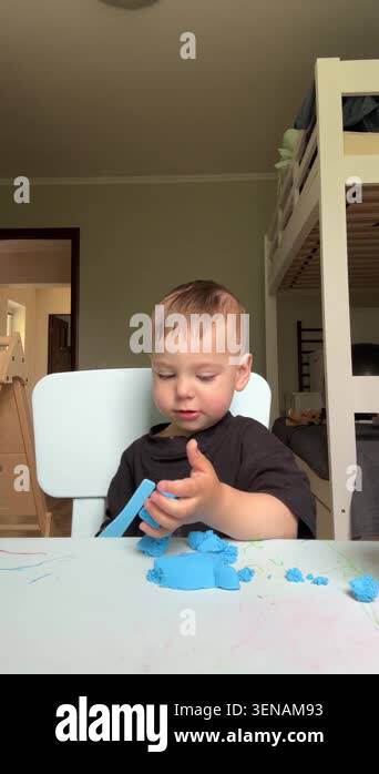 Toddler playing with blue kinetic sand at home Stock Video Footage - Alamy
