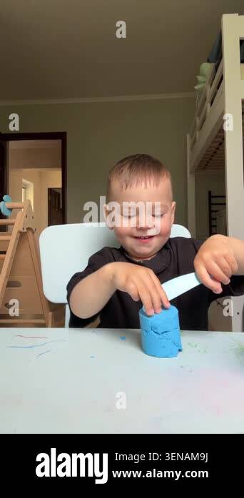 Toddler playing with blue kinetic sand at home Stock Video Footage - Alamy