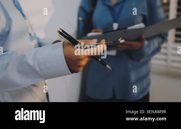 young asian doctor in white shirt and black uniform working on tablet ...