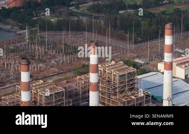 Industrial landscape featuring a power plant with tall red and white ...