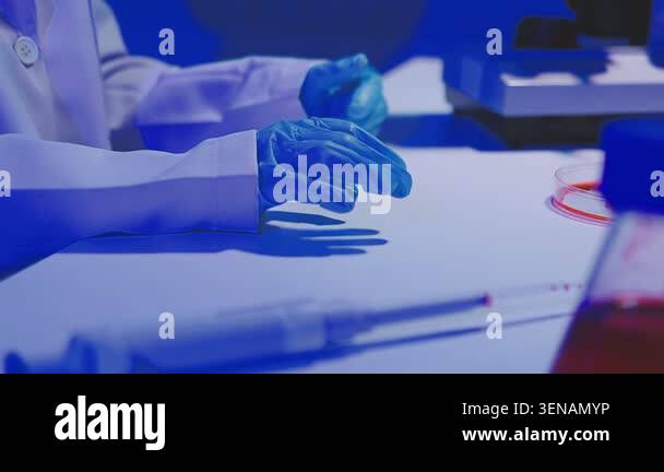 scientist in protective gloves and protective gloves doing a experiment ...