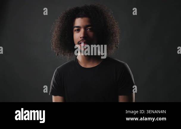 Thoughtful Young African American Man With Curly Hair And Black T-Shirt ...