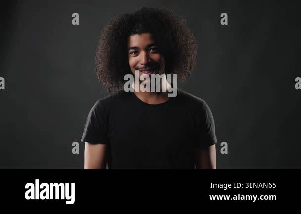 Confident Young Man With Curly Hair And Black T-Shirt Smiling At Camera ...