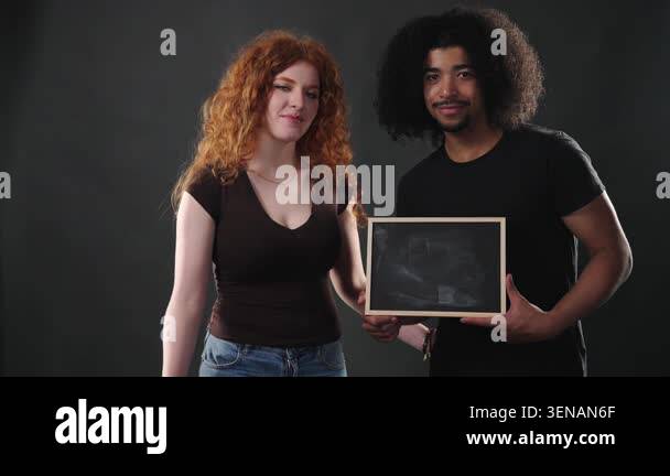 Diverse Couple Holding Blank Chalkboard For Message Or Advertisement ...