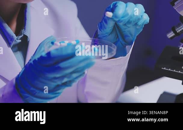 close up of female scientist holding test tube with blue liquid ...