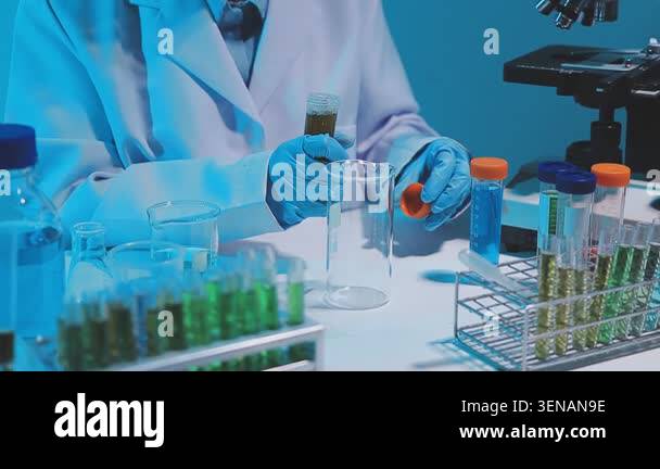 the laboratory assistant in the blue gloves holds the test tube with a ...