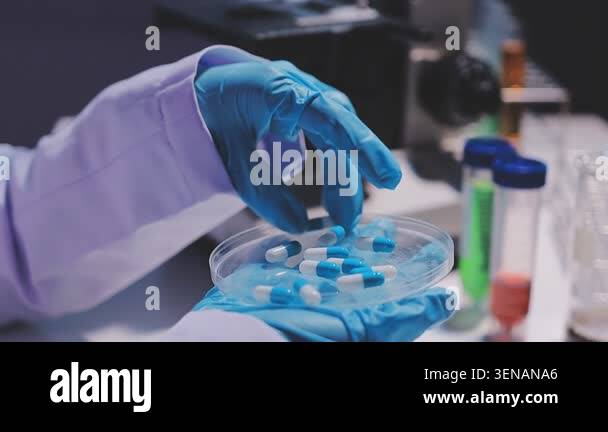scientist in blue gloves and gloves holding a tube with a liquid Stock ...