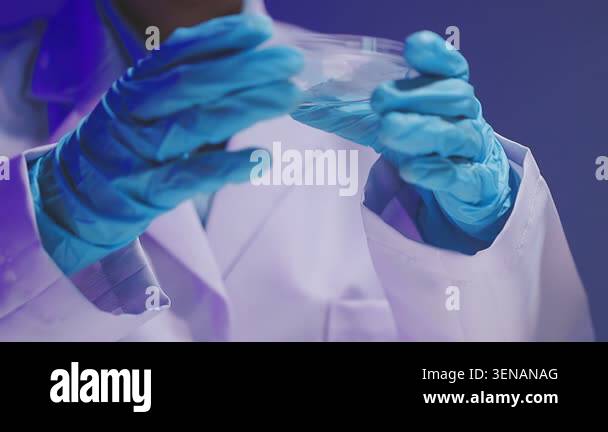 close up of scientist holding test tube with blue liquid in laboratory ...