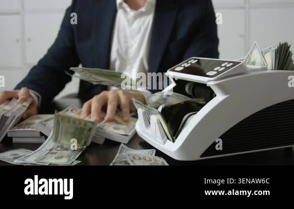 Businessman at office desk with money counting machine. Finance expert ...