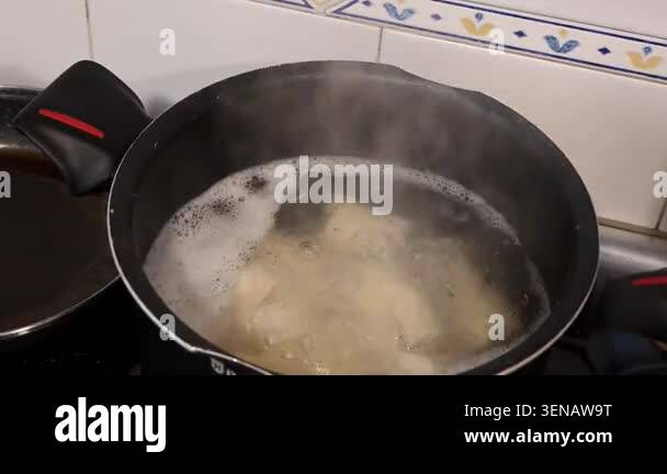 Italian gnocchi dumplings are boiling inside a hot pot of water on a ...
