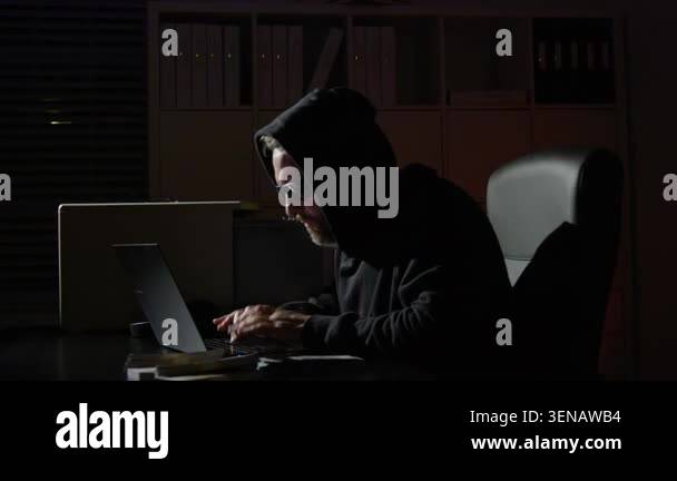 Office hacker typing malware at night. Digital hacker attack threatens ...
