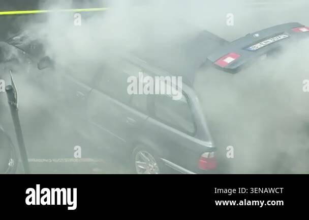 Thick smoke engulfs a burned station wagon after firefighters opened ...