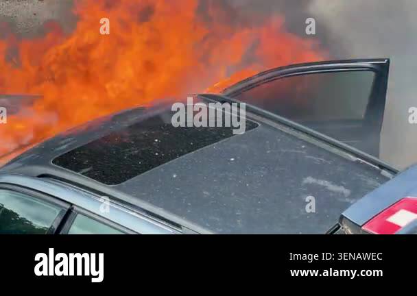 Flames and smoke spread across the roof and open door of a burning ...