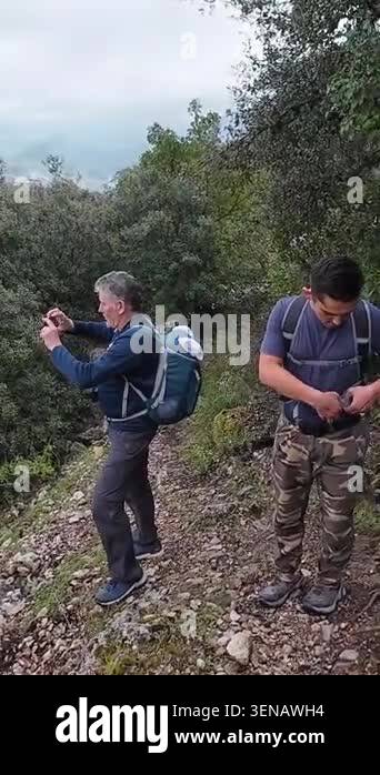 Two male tourists, a senior father and his adult son, stop on a ...