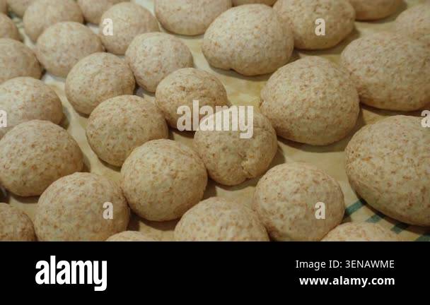 Numerous small balls of whole wheat dough rising on a tray ...