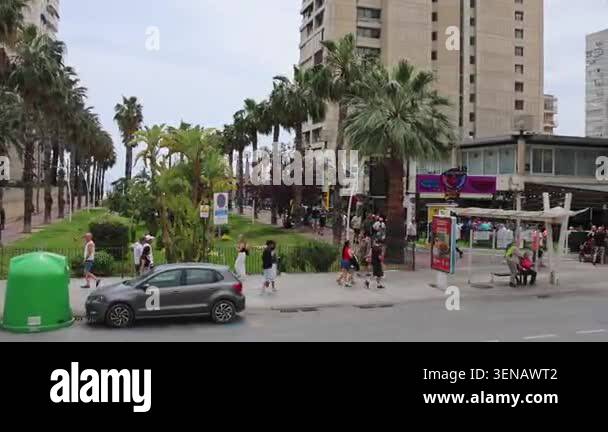 Busy street with tourists and palm trees in Benidorm Spain. 21.04.2026 ...