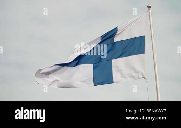Close up of the Finnish flag waving in strong wind outdoors. Slow ...