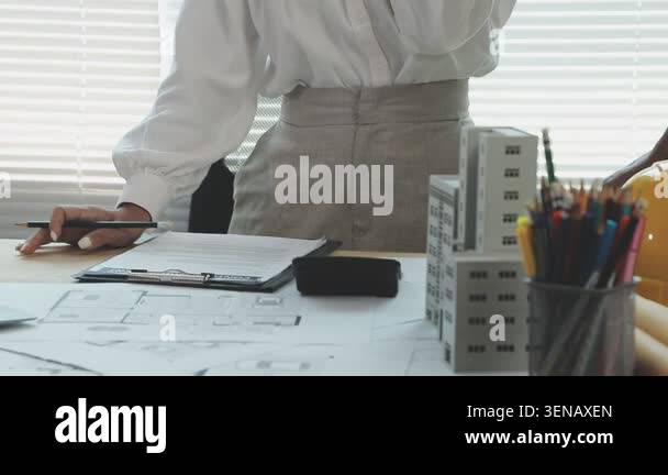 female engineer in white shirt working on blueprint and holding ...