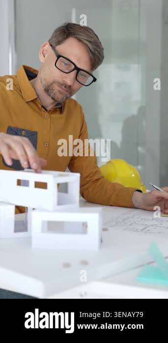 Professional architect concentrating on architectural blueprints and a ...