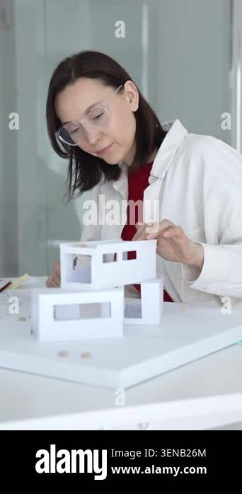 Woman architect focusing on architectural drawings and blueprints ...