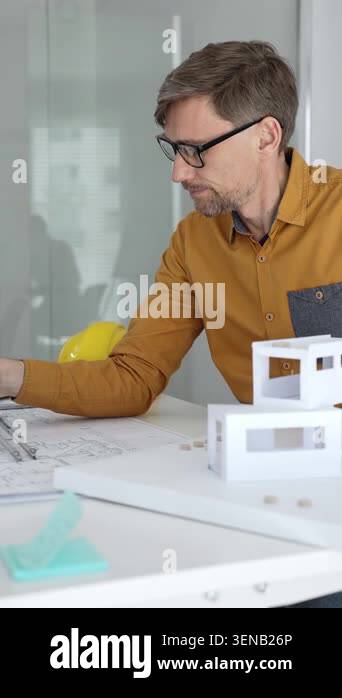 Professional architect concentrating on architectural blueprints and a ...