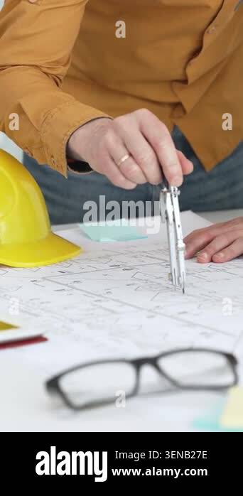 Professional architect concentrating on architectural blueprints and a ...