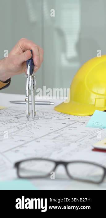 Professional architect concentrating on architectural blueprints and a ...