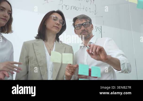 Three professionals collaborate in a modern office, brainstorming and ...