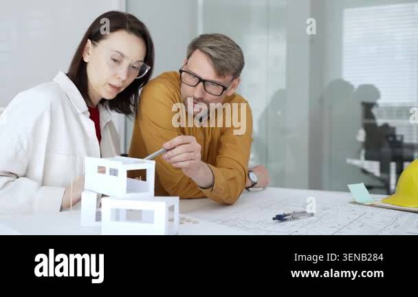 Architects hands working on blueprints and architectural models ...