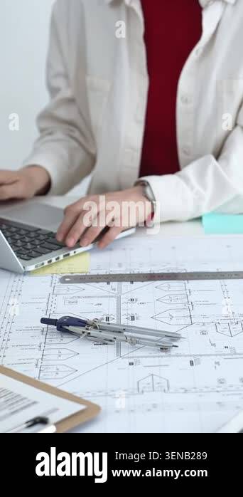 Professional female architect analyzing building blueprints and floor ...