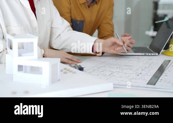 Architects hands working on blueprints and architectural models ...