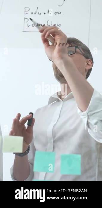 Businessman brainstorming marketing strategy, writing ideas on a ...