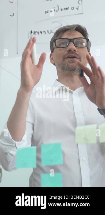 Businessman brainstorming marketing strategy, writing ideas on a ...