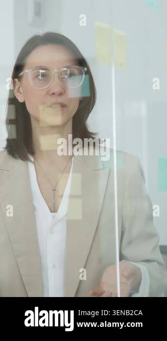 Young businesswoman with clear glasses actively discussing and ...