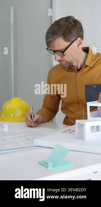 Professional architect concentrating on architectural blueprints and a ...