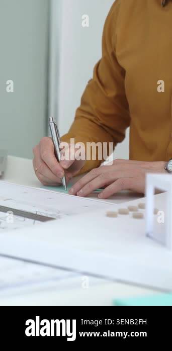 Professional architect concentrating on architectural blueprints and a ...