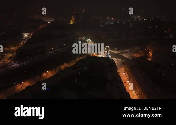 Aerial night view of dark snowy city blocks, illuminated roads ...