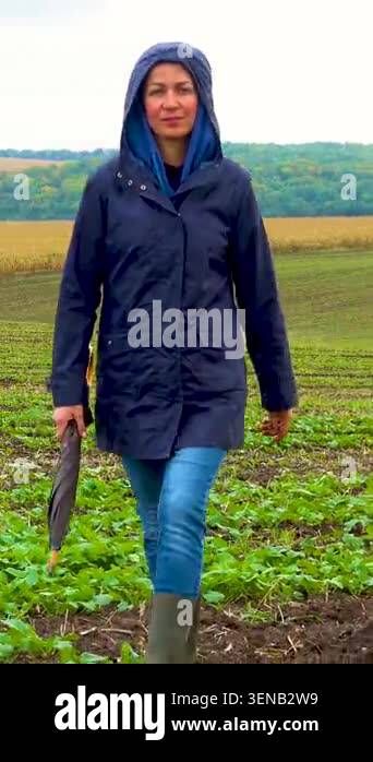 A woman walks her dog in a field after a thunderstorm. Girl with ...