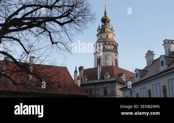 Low angle view of a historic castle tower rising above the red tiled ...