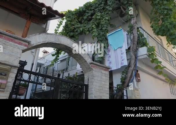 A low angle shot shows a white building featuring a stone archway ...