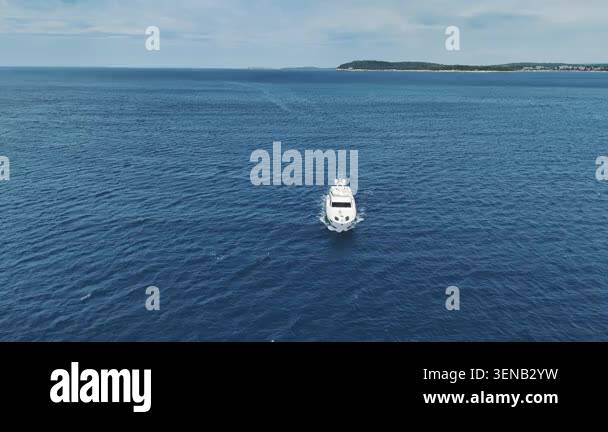 An aerial drone view shows a luxury white motor yacht cruising through ...