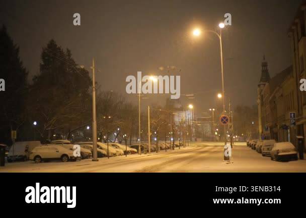 An empty urban street covered in thick snow during a winter night ...