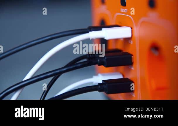 Close up hand unplugging cables from portable charging station with ...