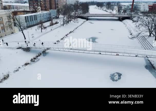 An aerial perspective shows a frozen river with patches of open water ...